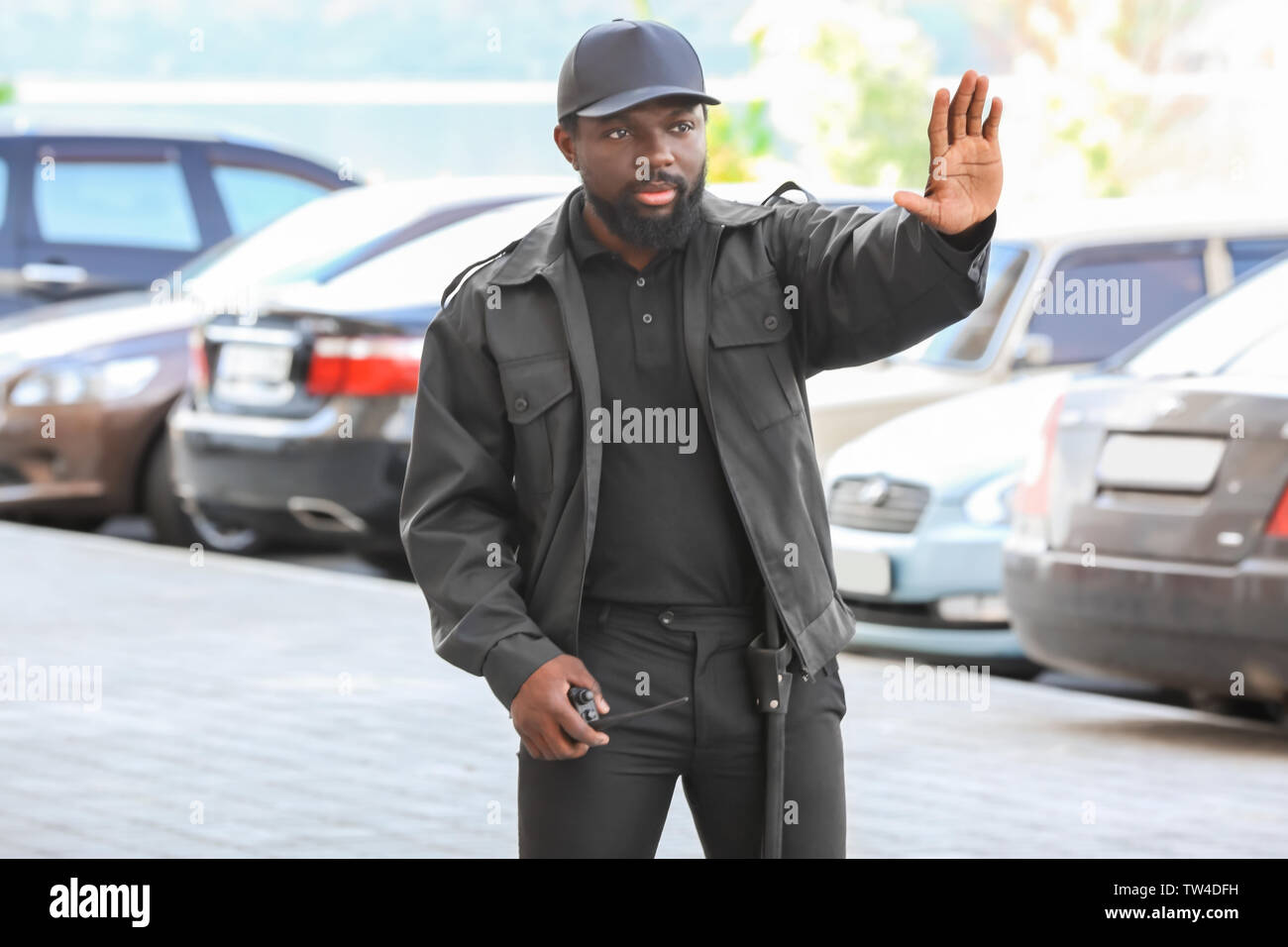 Security guard showing stop gesture outdoors Stock Photo - Alamy