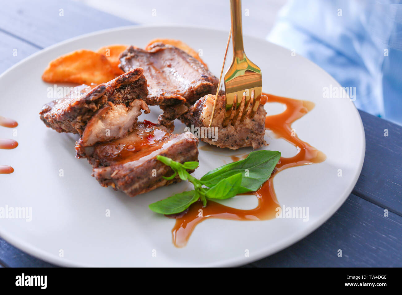 Eating delicious ribs in restaurant Stock Photo - Alamy