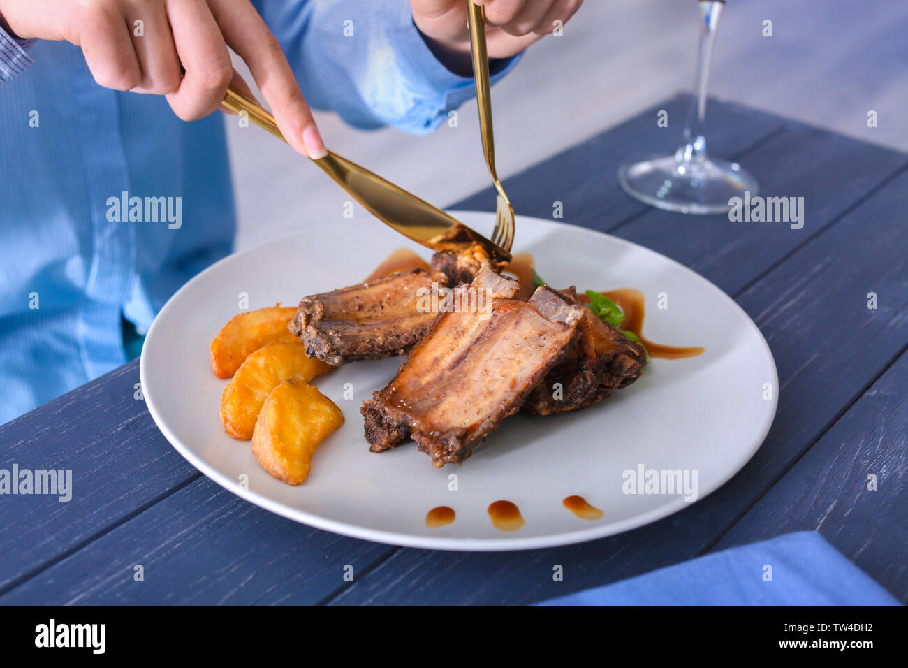 Young woman eating delicious ribs in restaurant Stock Photo - Alamy