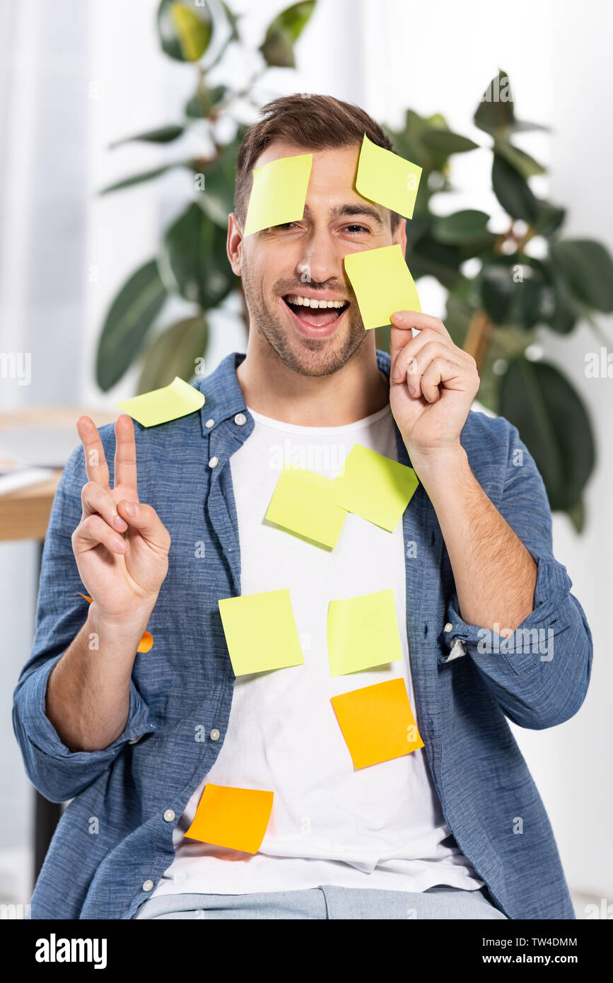 happy man in yellow and orange sticky notes showing peace sign Stock ...