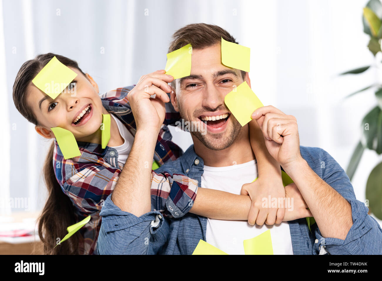 cheerful kid hugging happy father in yellow sticky notes Stock Photo ...