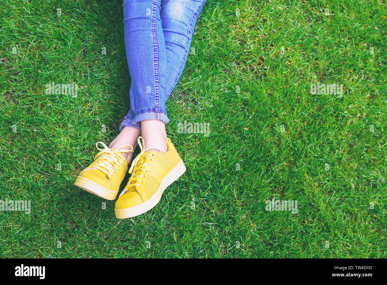 Beautiful female legs on green grass background Stock Photo - Alamy