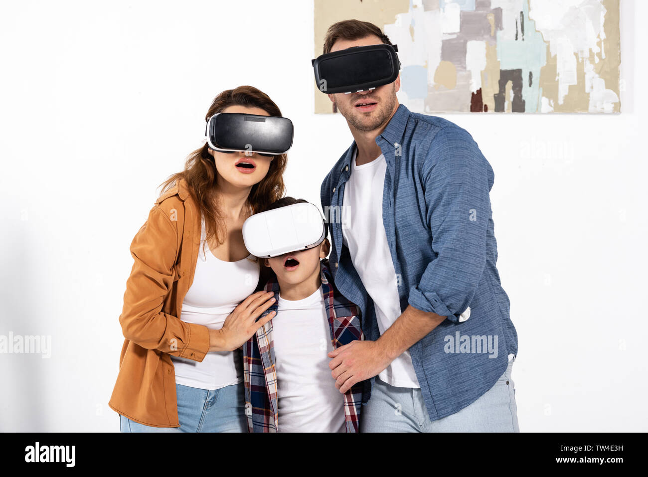 shocked parents and surprised kid wearing virtual reality headsets at ...