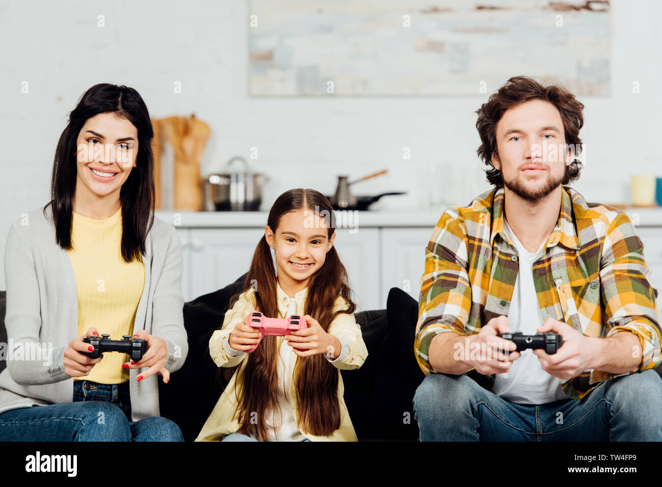 cute and happy kid playing video game with parents at home Stock Photo ...
