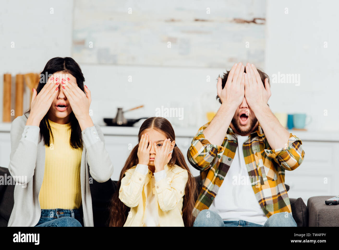 shocked family covering face while watching tv at home Stock Photo - Alamy
