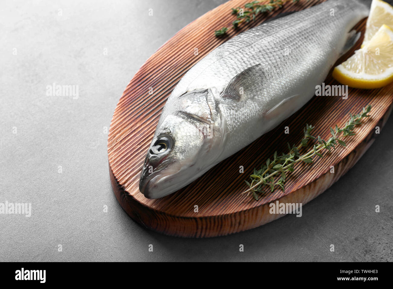 Fresh fish with thyme and lemon on gray background Stock Photo - Alamy