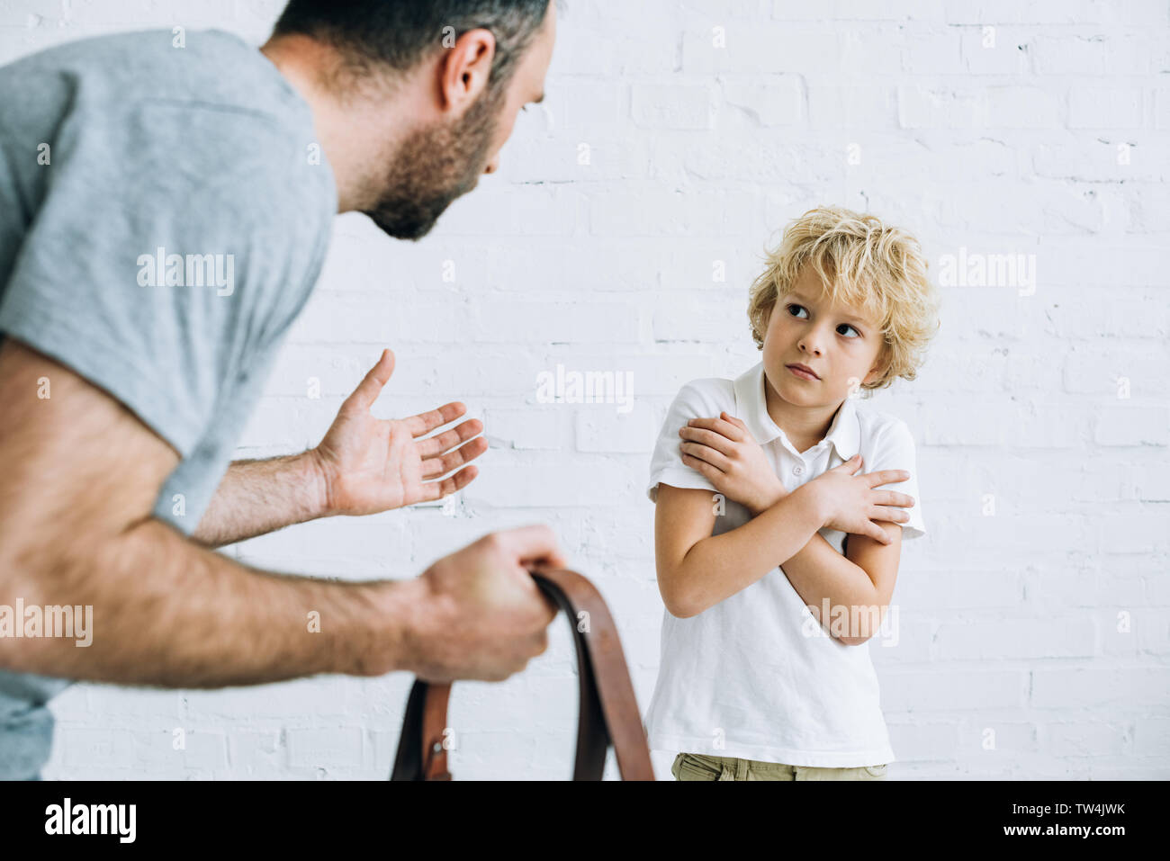 cropped view of father holding belt and scolding son at home Stock ...