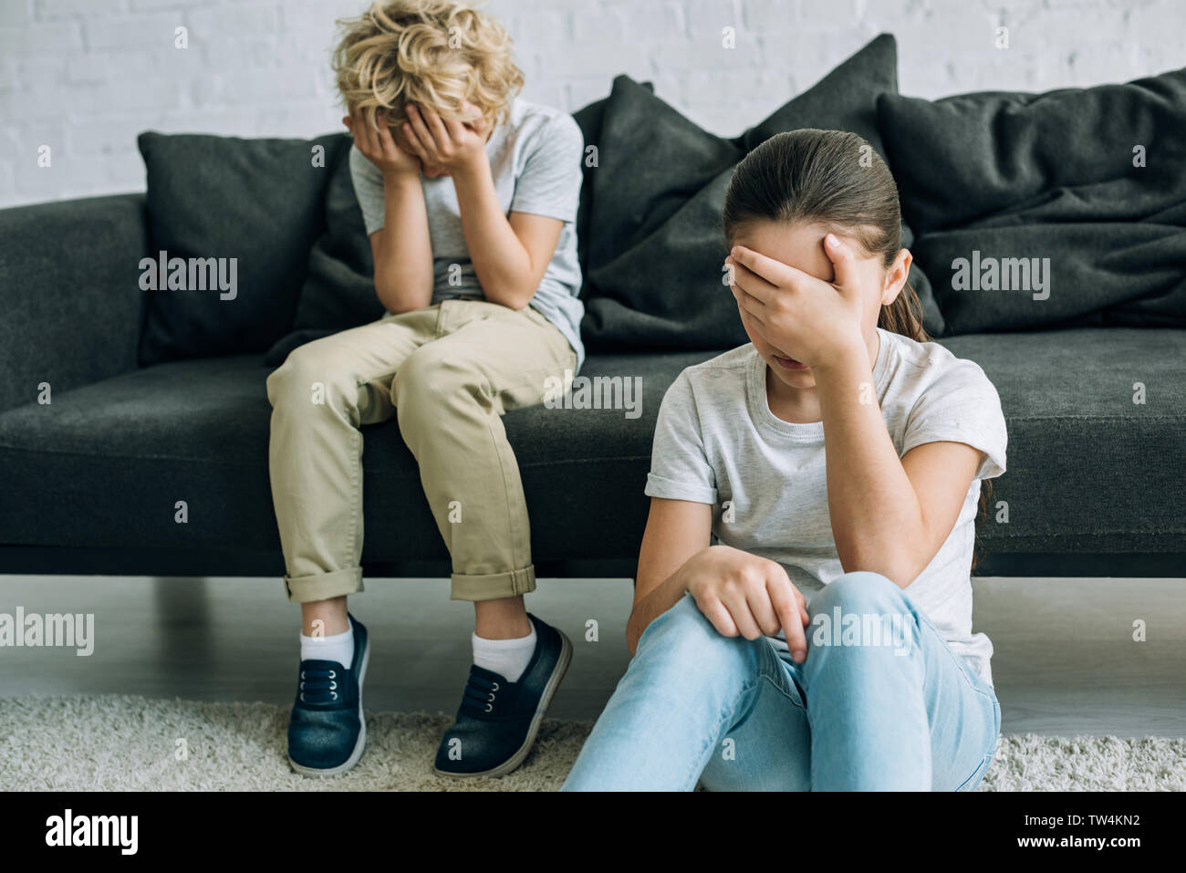 two sad preteen kids crying in living room Stock Photo - Alamy
