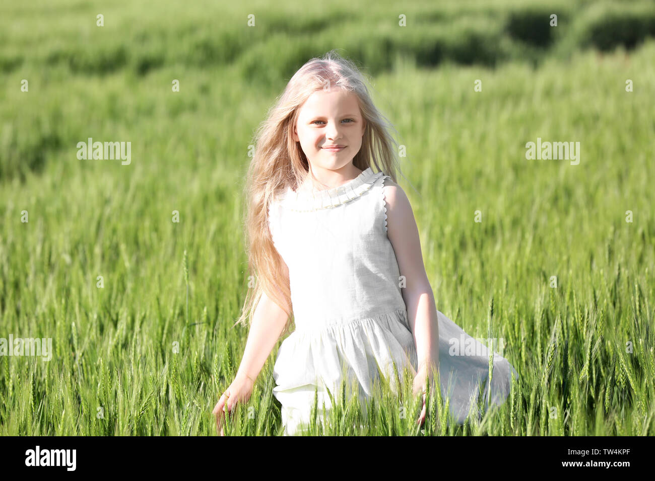 Little girl in green field Stock Photo - Alamy