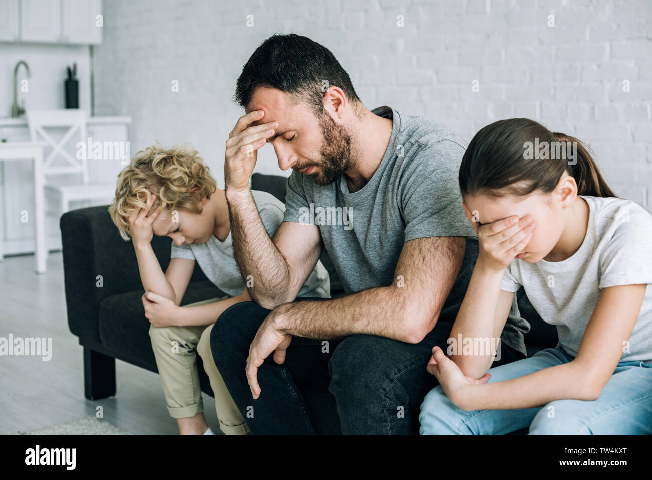 two sad preteen children and father having conflict Stock Photo - Alamy