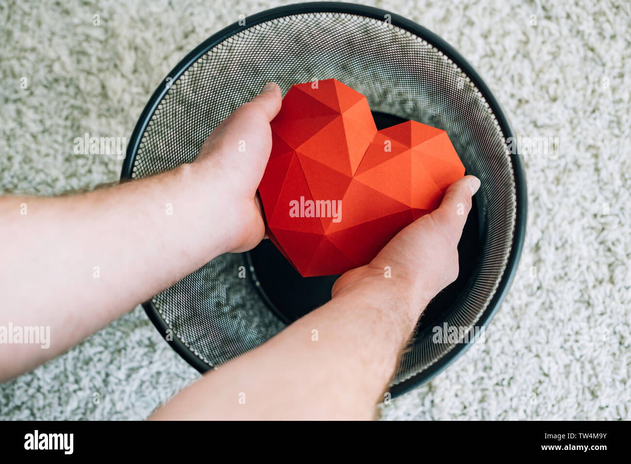 partial view of man throwing out heart in trash can Stock Photo - Alamy