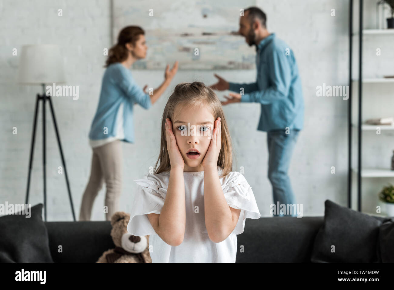 selective focus of shocked kid touching face while standing near ...