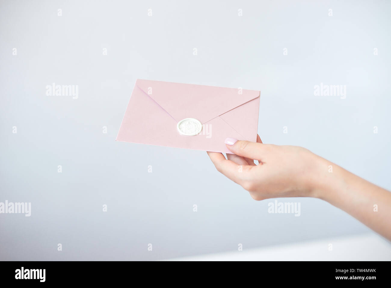 Close-up woman with slim body holding in hands the invitation card blue ...