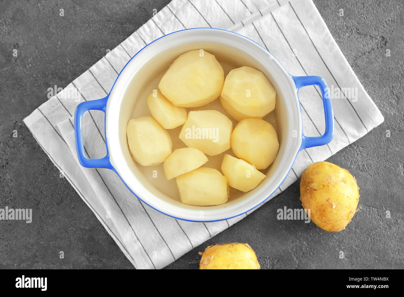 Cooking pot with raw organic potatoes on table Stock Photo - Alamy