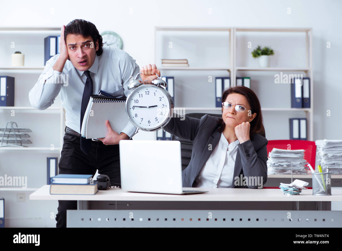 Old female boss and young male employee in the office Stock Photo - Alamy