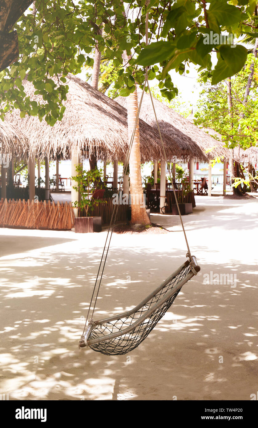 Swings on beach at tropical resort Stock Photo - Alamy