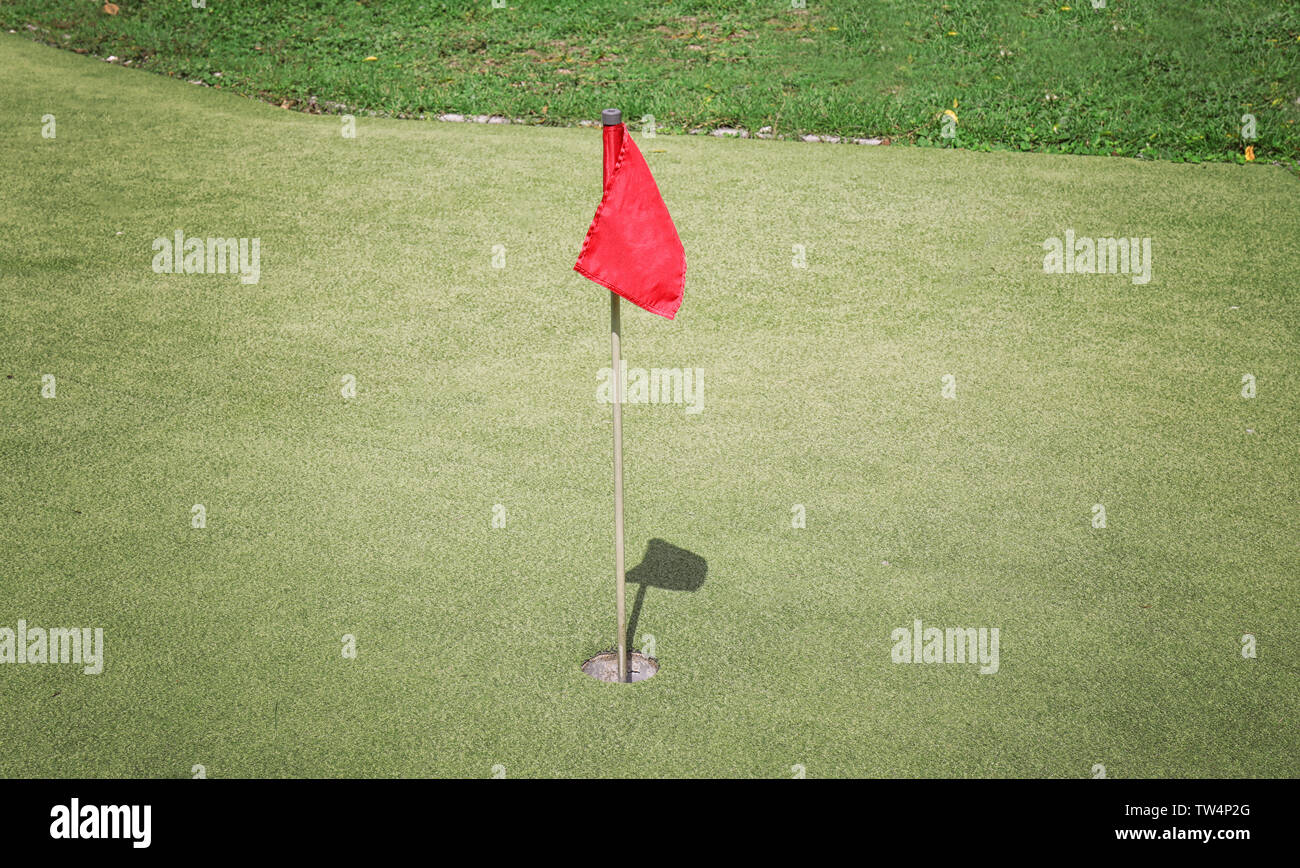Flag and hole on golf course Stock Photo - Alamy