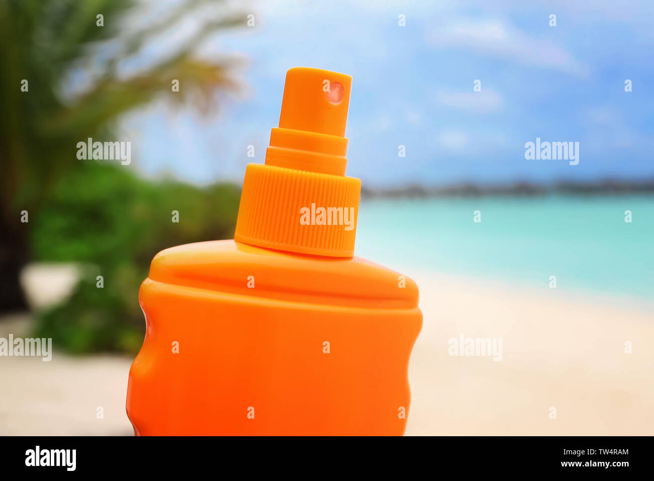 Bottle of sunscreen cream and blurred tropical beach on background ...