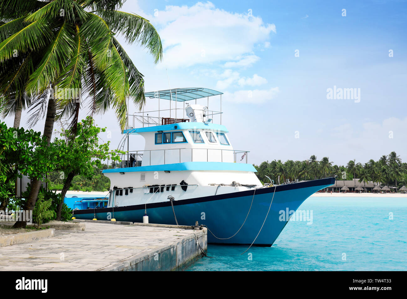Modern boat berthed at tropical resort Stock Photo - Alamy