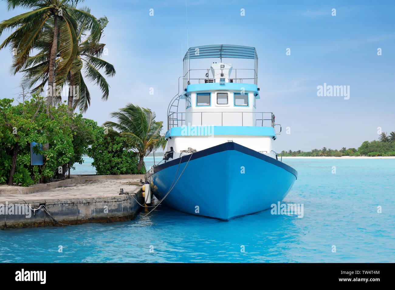 Modern boat berthed at tropical resort Stock Photo - Alamy