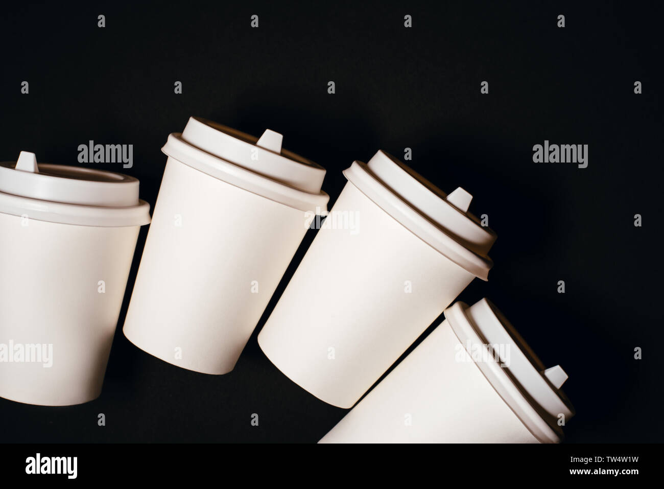 Four paper cups for coffee or tea on black background Stock Photo - Alamy