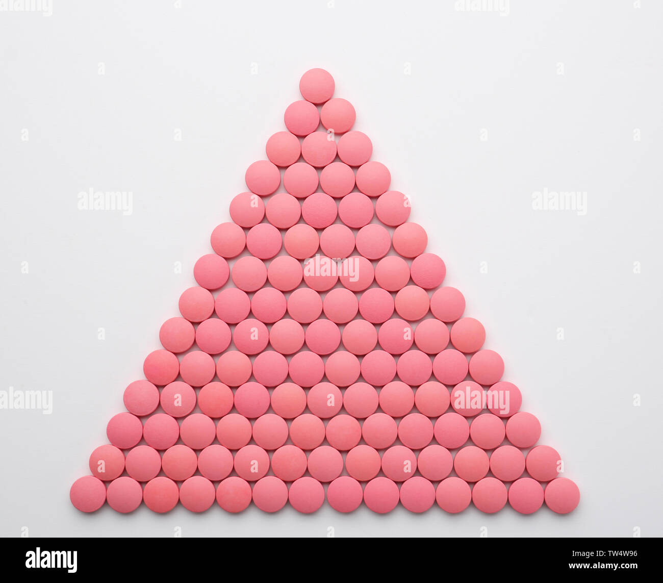 Triangle made of pills on white background Stock Photo - Alamy