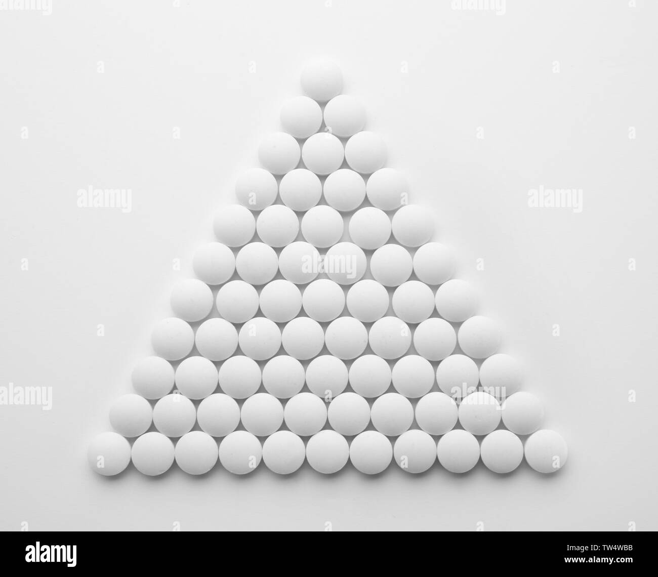 Triangle made of pills on white background Stock Photo - Alamy