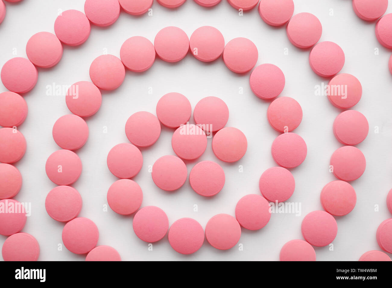 Spiral made of color round pills on white background Stock Photo - Alamy
