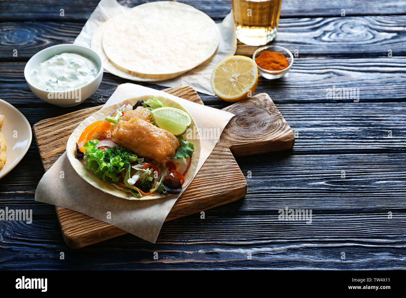 Wooden board with delicious fish taco on table Stock Photo - Alamy