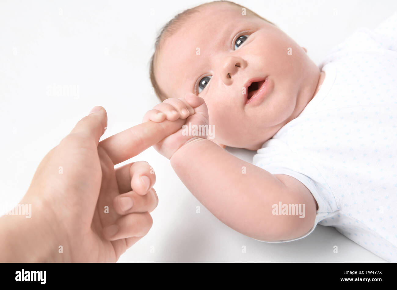 Cute little baby holding mother's finger on white background Stock ...