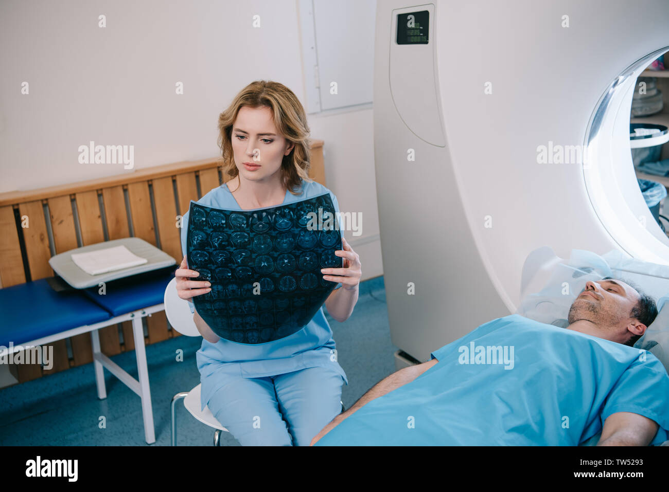 attentive radiologist examining radiology diagnosis near patient lying ...