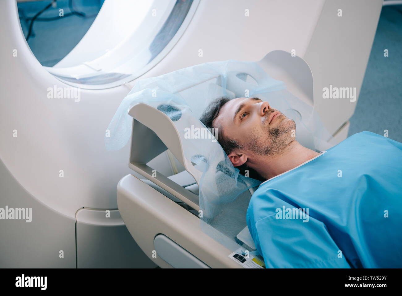 adult handsome man lying on ct scan bed during tomography test Stock ...