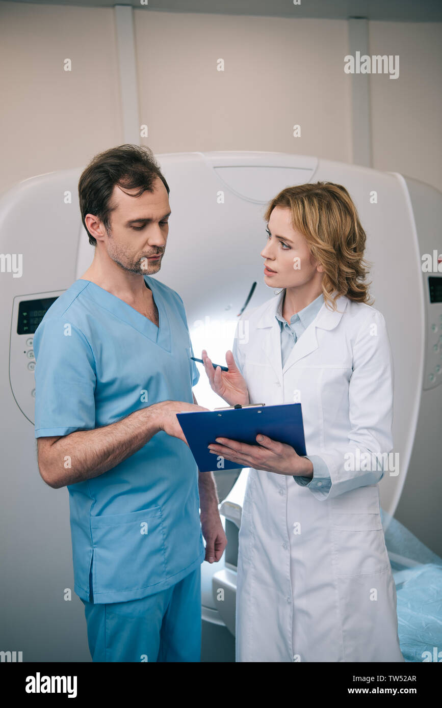 two serious radiographers talking while examining radiology diagnosis ...