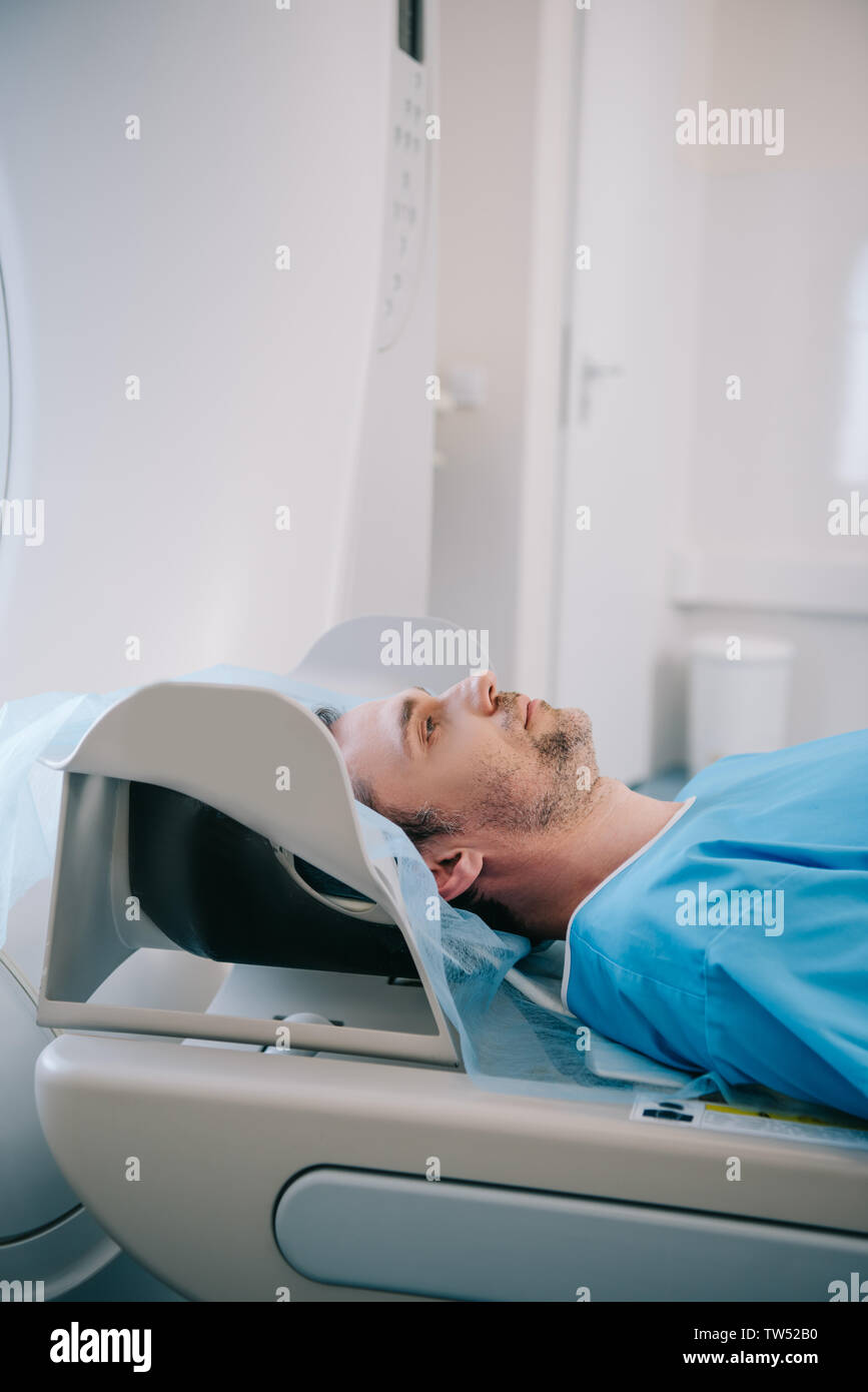 handsome man lying on ct scanner bed during tomography diagnostics in ...