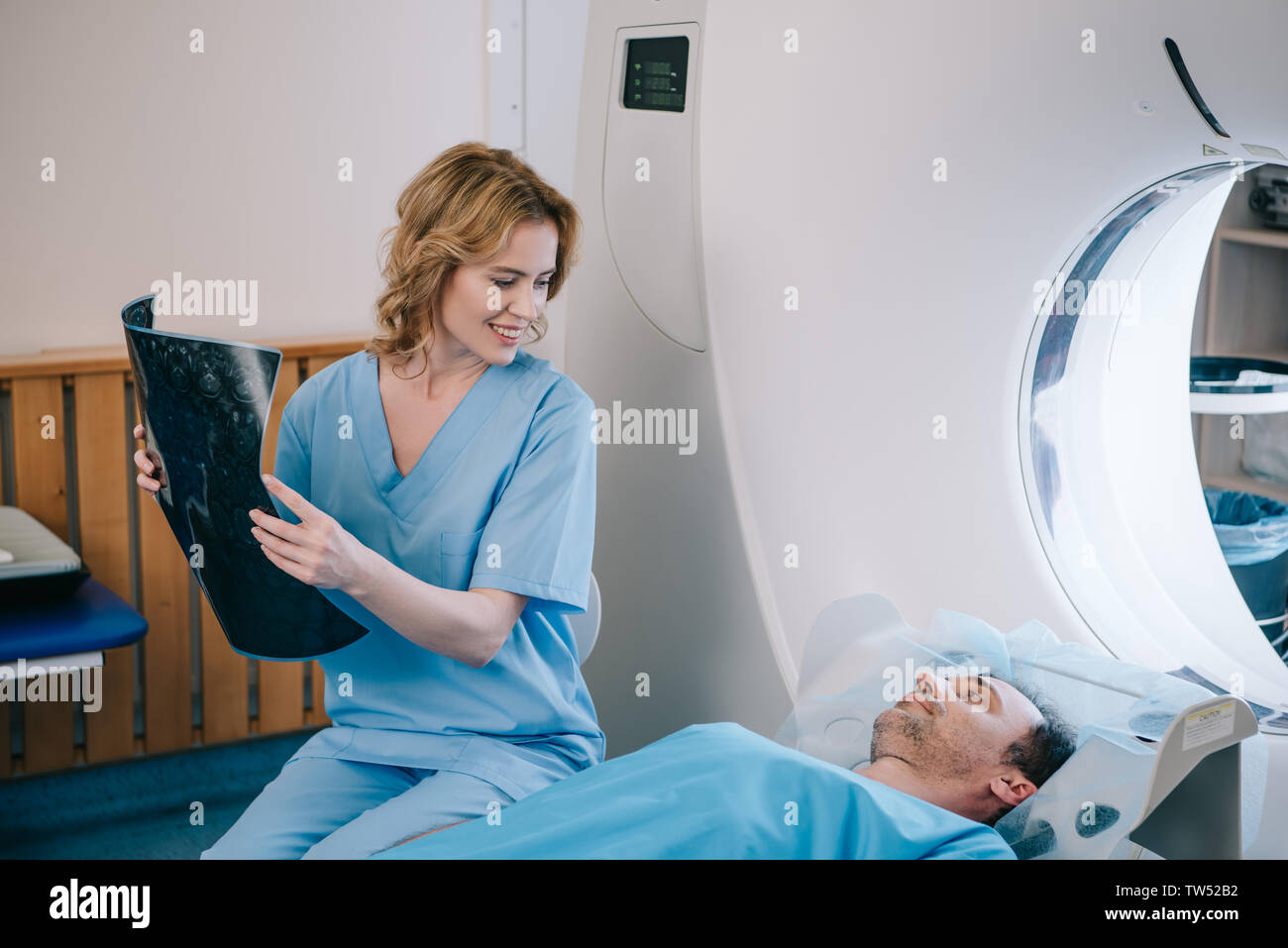 beautiful smiling doctor holding radiology diagnosis and looking at man ...