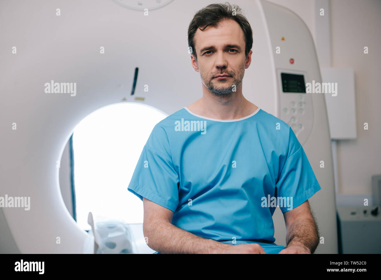 thoughtful man sitting on ct scanner bed and looking at camera Stock ...