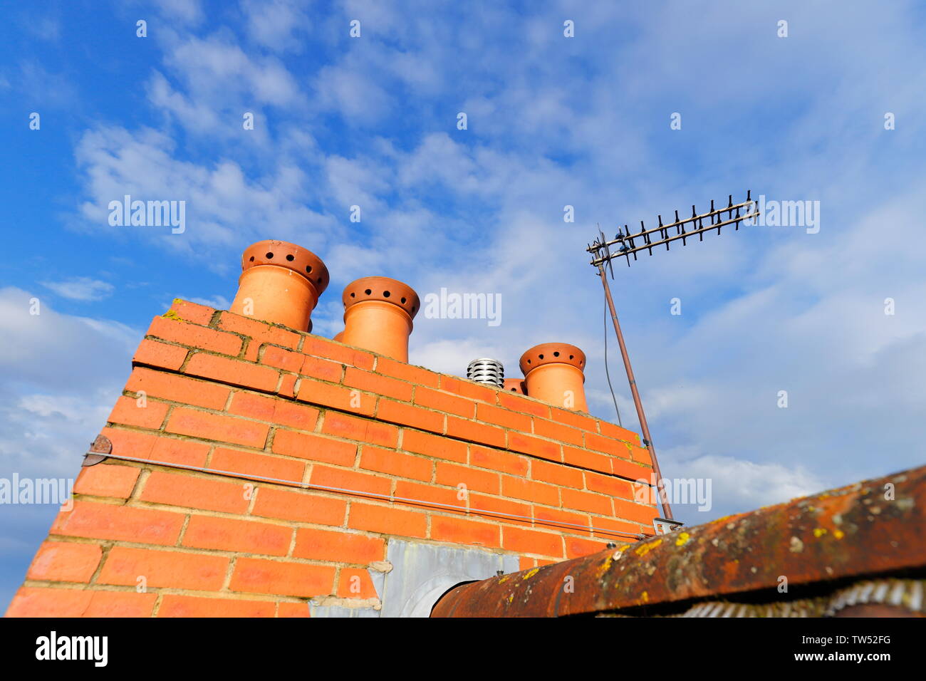 a brick chimney & analogue tv aerial on a row fo terrace houses in ...