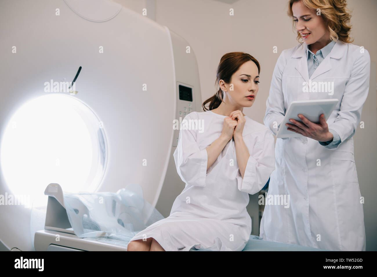 smiling radiographer showing digital tablet with x-ray diagnosis to ...