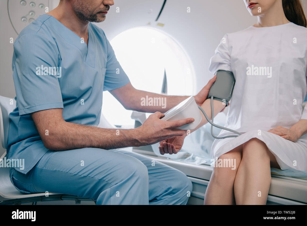 partial view of doctor measuring patients blood pressure with tonometer ...