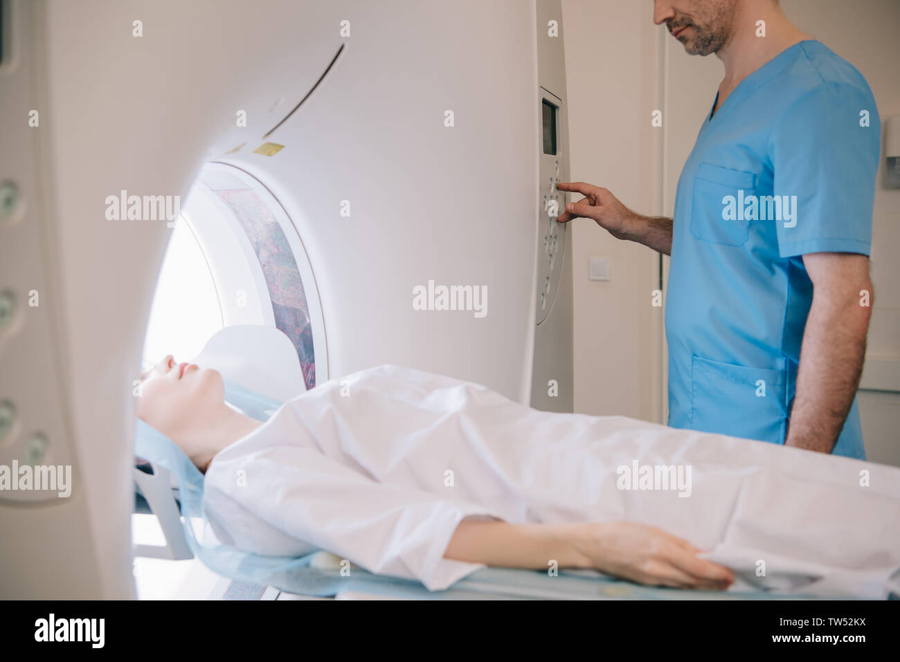 partial view of radiologist operating mri machine during patients ...