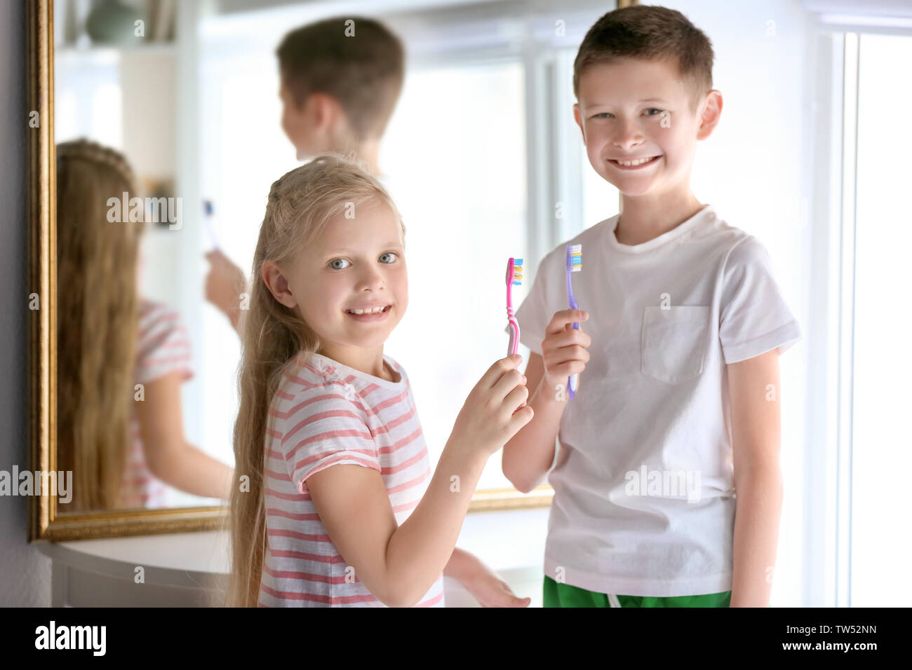Cute little children cleaning teeth at home Stock Photo - Alamy