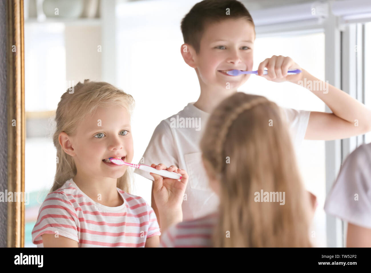 Cute little children cleaning teeth at home Stock Photo - Alamy