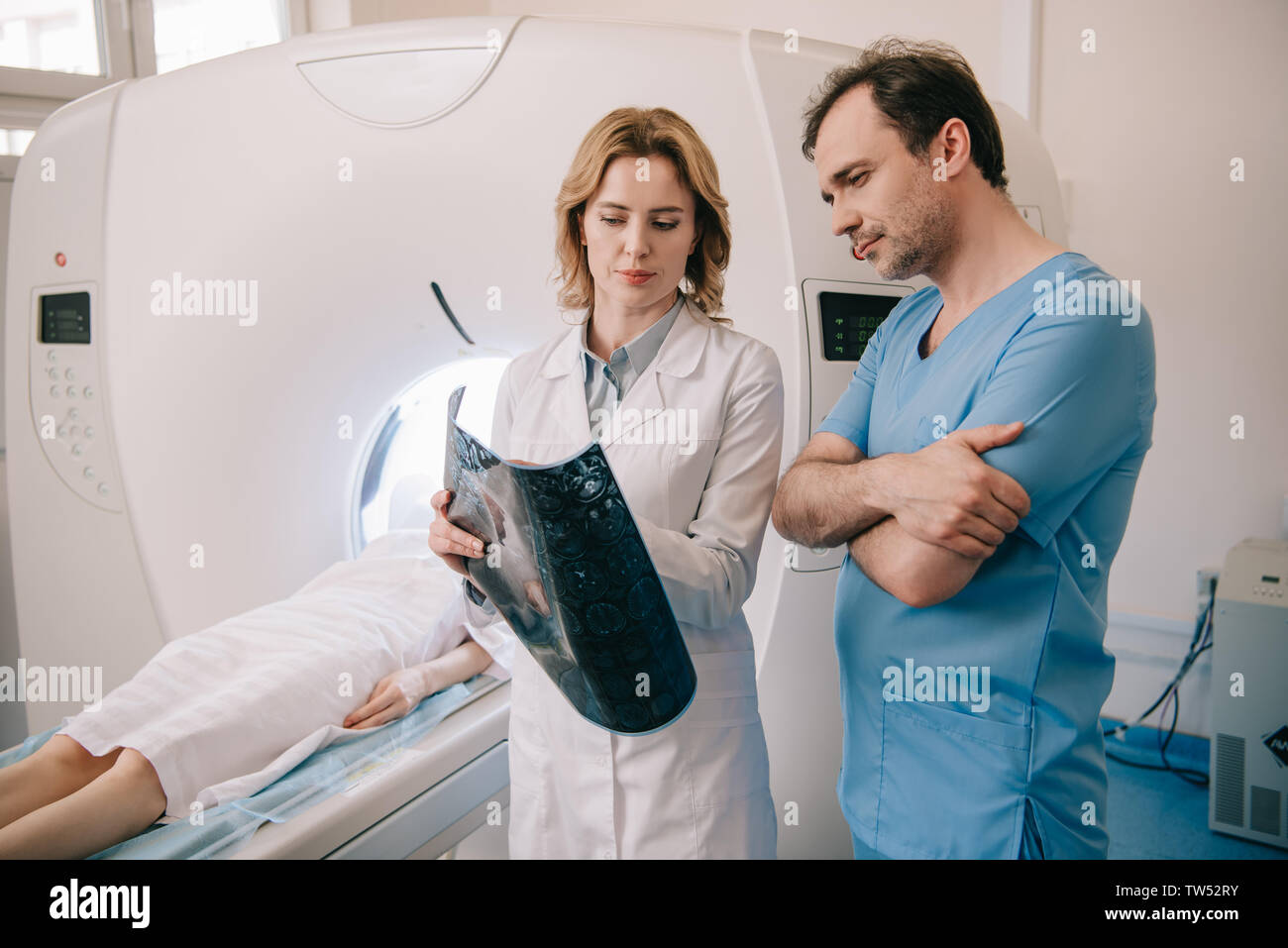 thoughtful doctors looking at x-ray diagnosis during patients ...