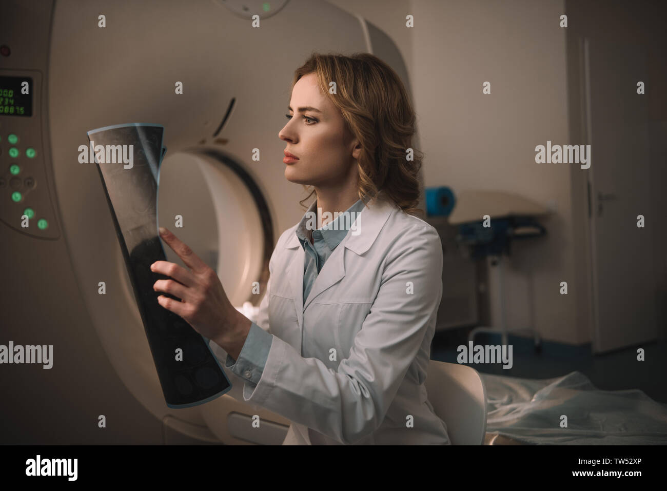 thoughtful radiologist examining x-ray diagnosis while sitting near ct ...