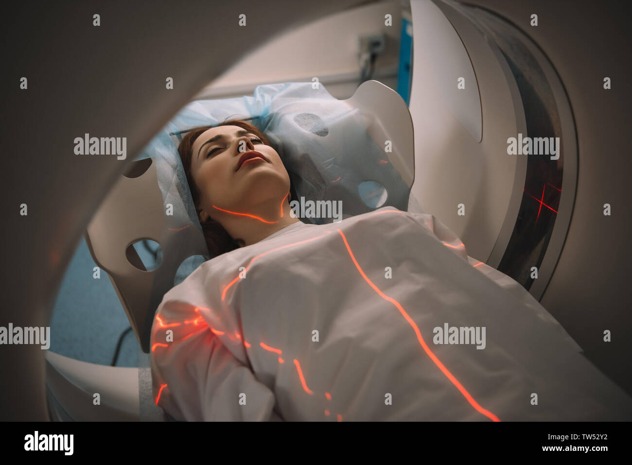 beautiful woman lying on ct scanner bed during tomography test in ...