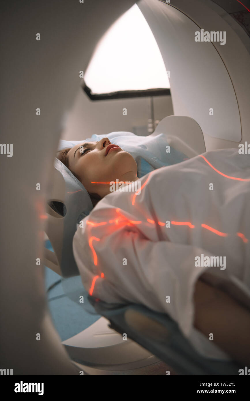 young woman lying on ct scanner bed during tomography diagnostics in ...