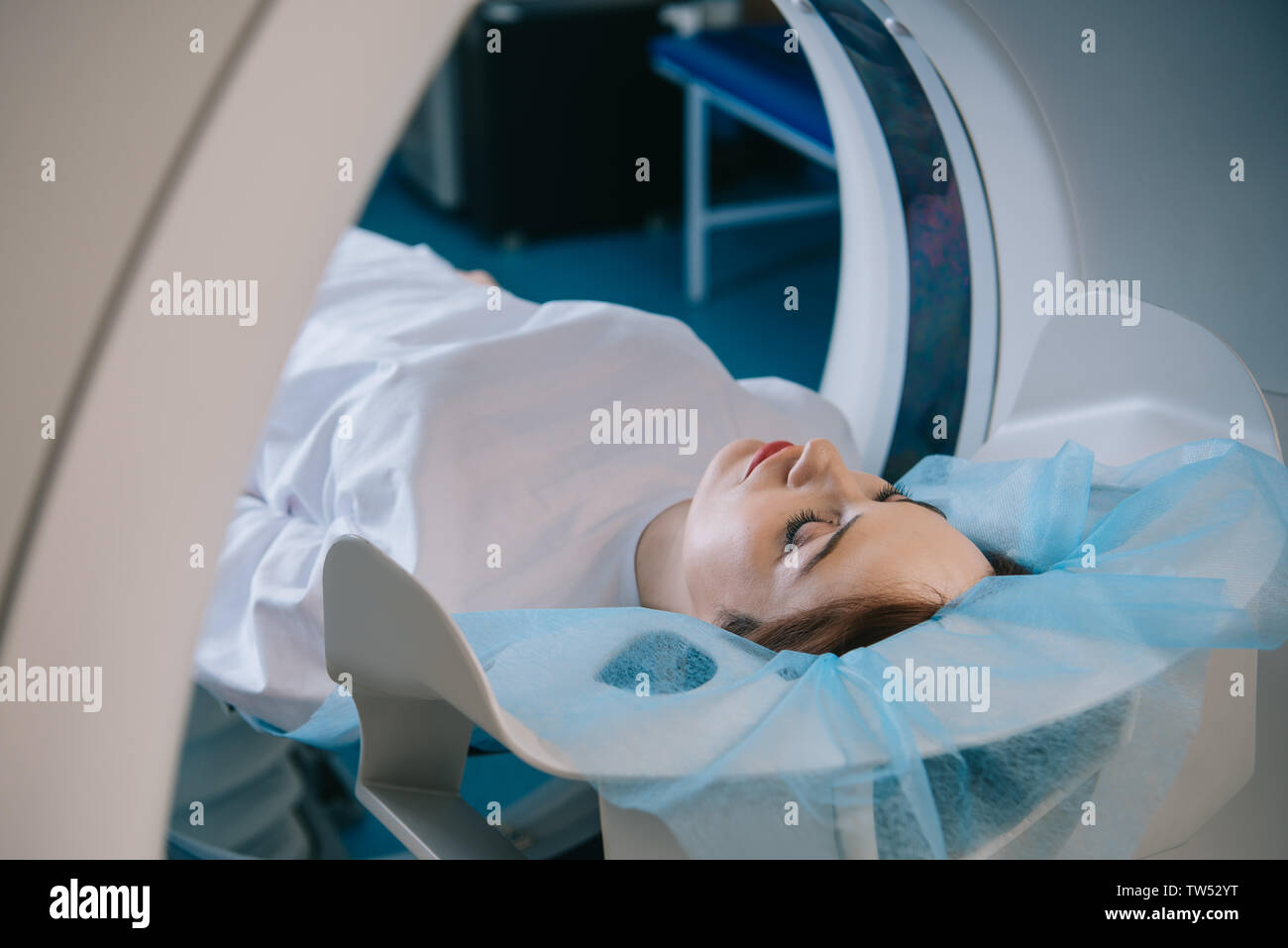 young woman lying on ct scanner bed during tomography diagnostics in ...