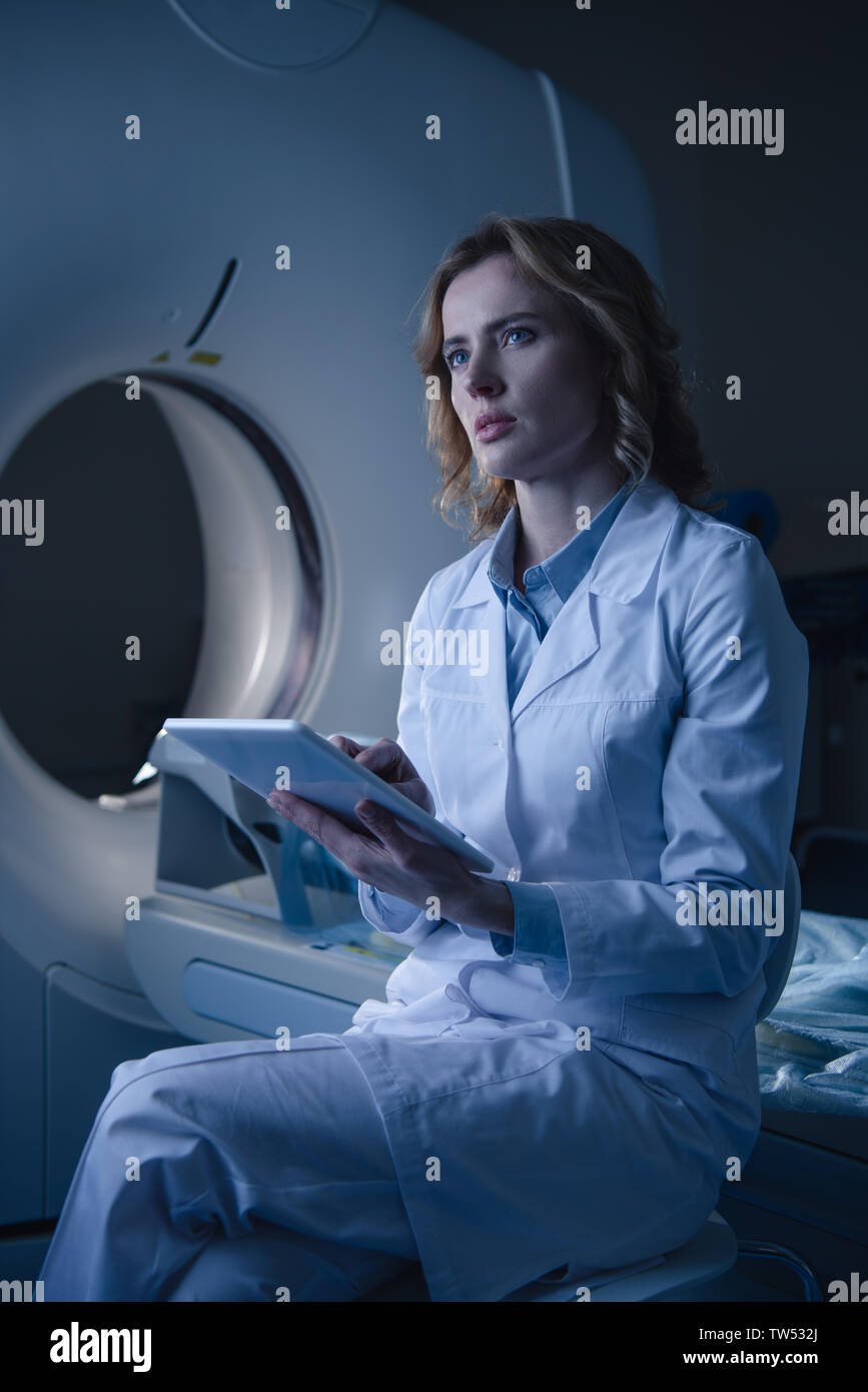 thoughtful radiologist holding digital tablet with x-ray diagnosis ...
