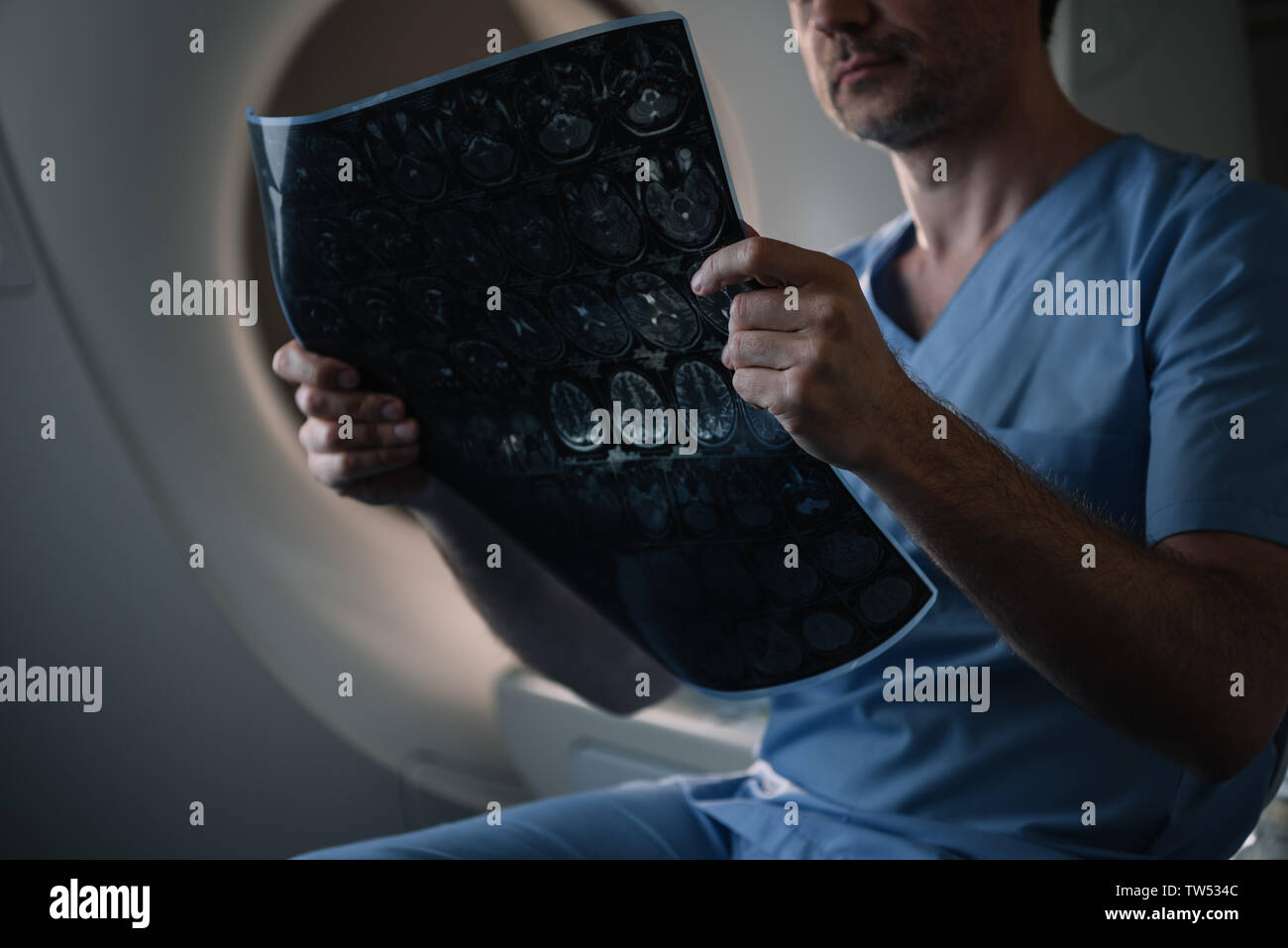 cropped shot of radiologist examining x-ray diagnosis while sitting ...