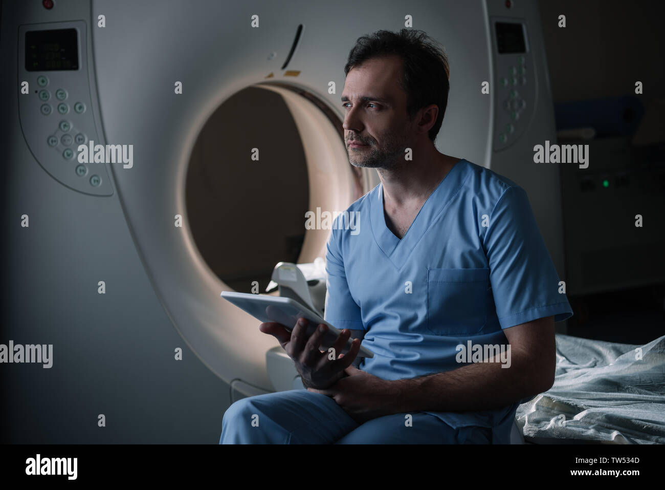 serious radiologist holding digital tablet with x-ray diagnosis while ...